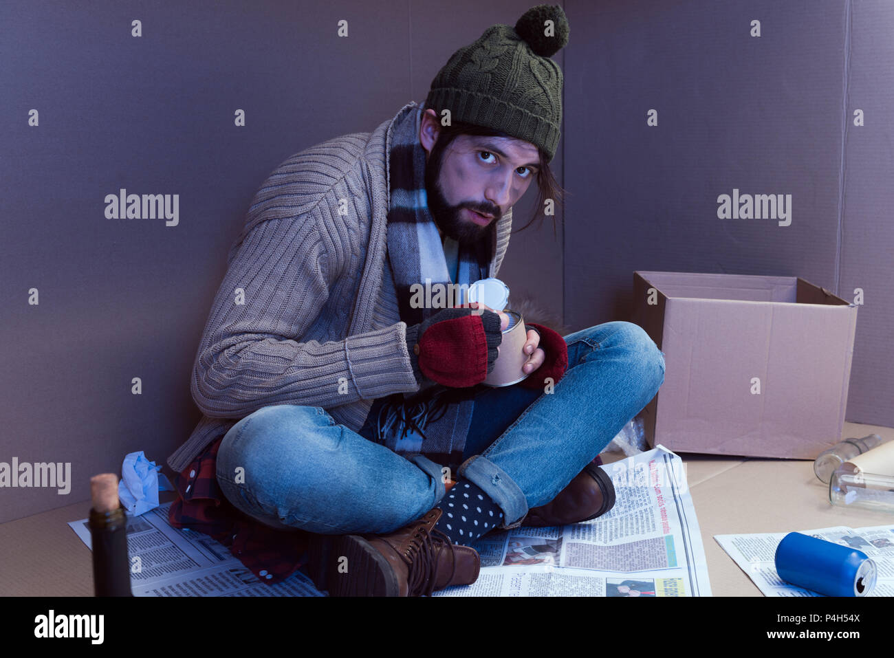 homeless man eating canned food in cardboard box Stock Photo - Alamy