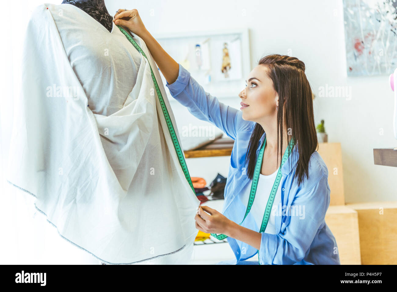 attractive tailor measuring fabric for dress Stock Photo - Alamy