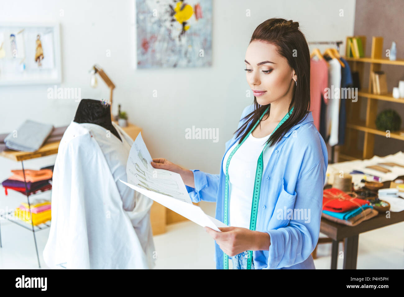 designer looking at sketches of white dress Stock Photo - Alamy