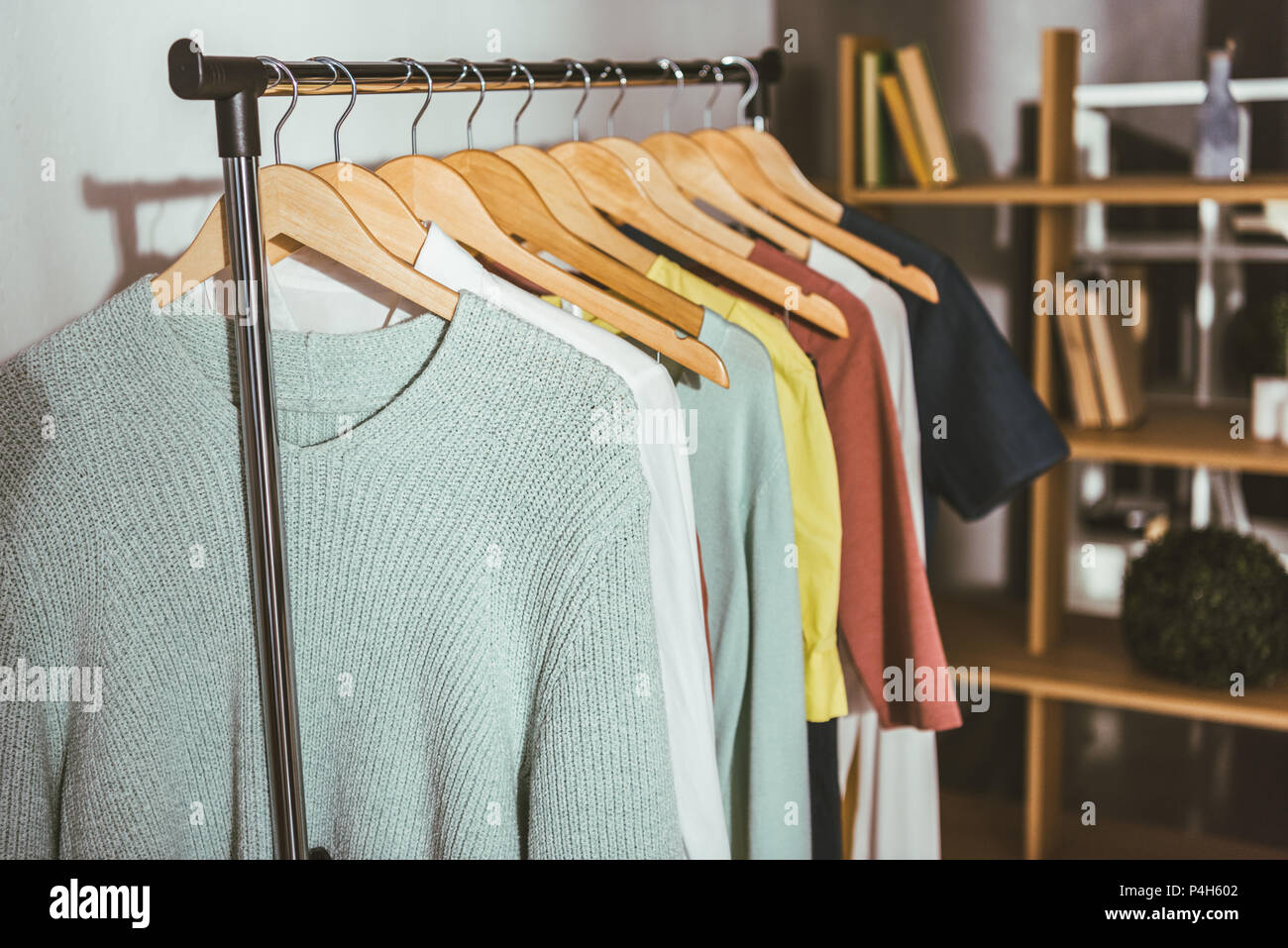 different colored sweaters and shirts on hangers Stock Photo - Alamy