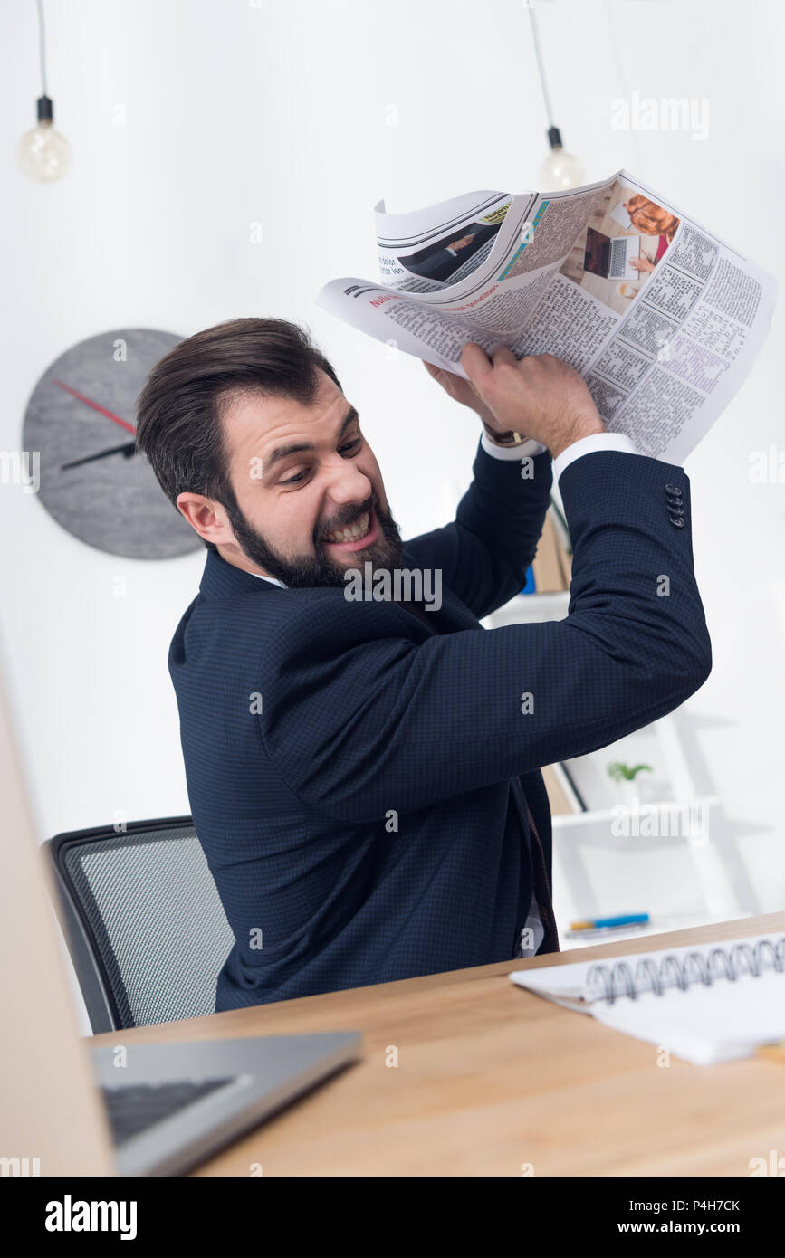portrait of angry businessman throwing newspaper at workplace Stock ...