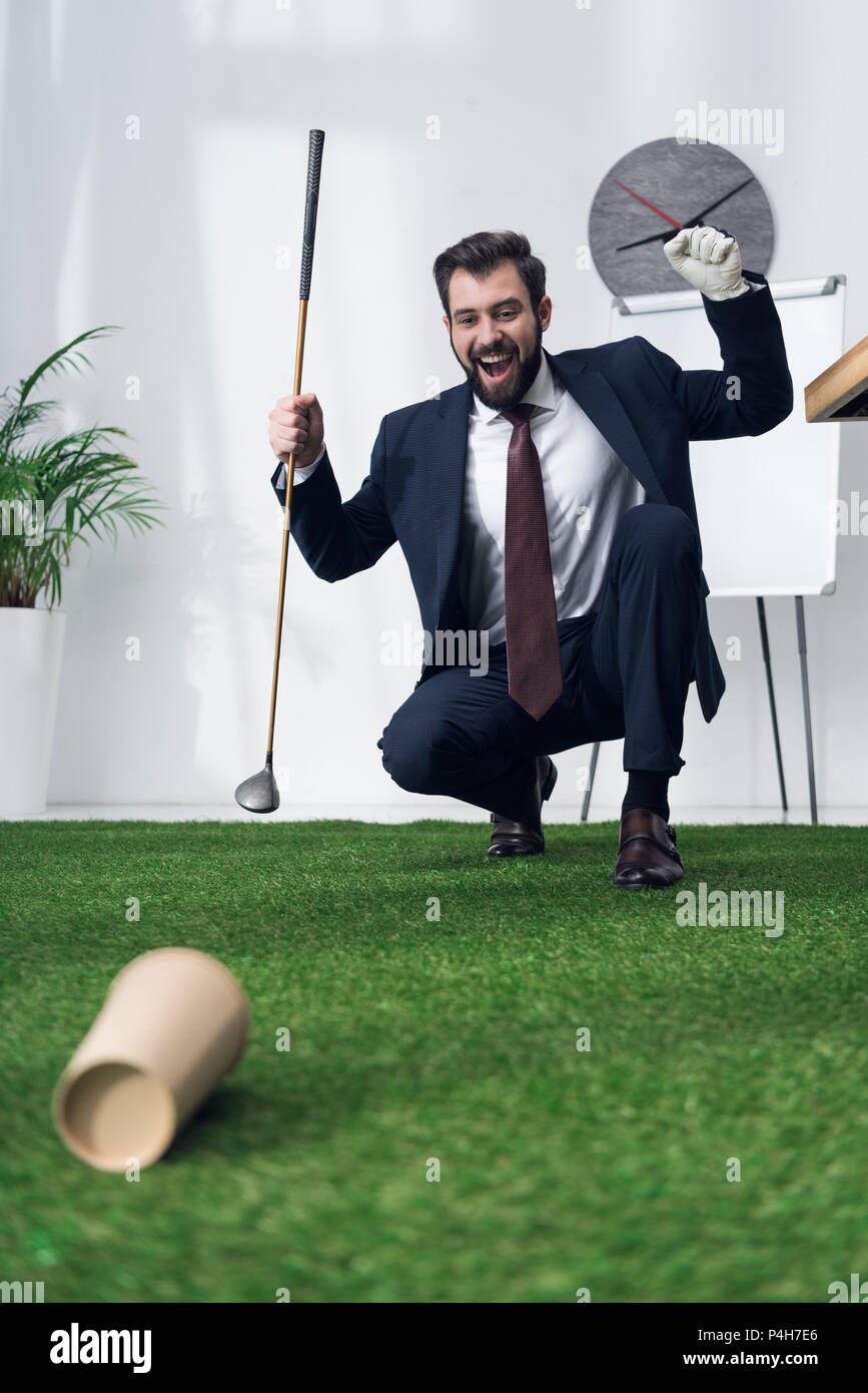 excited young businessman playing golf in office Stock Photo - Alamy