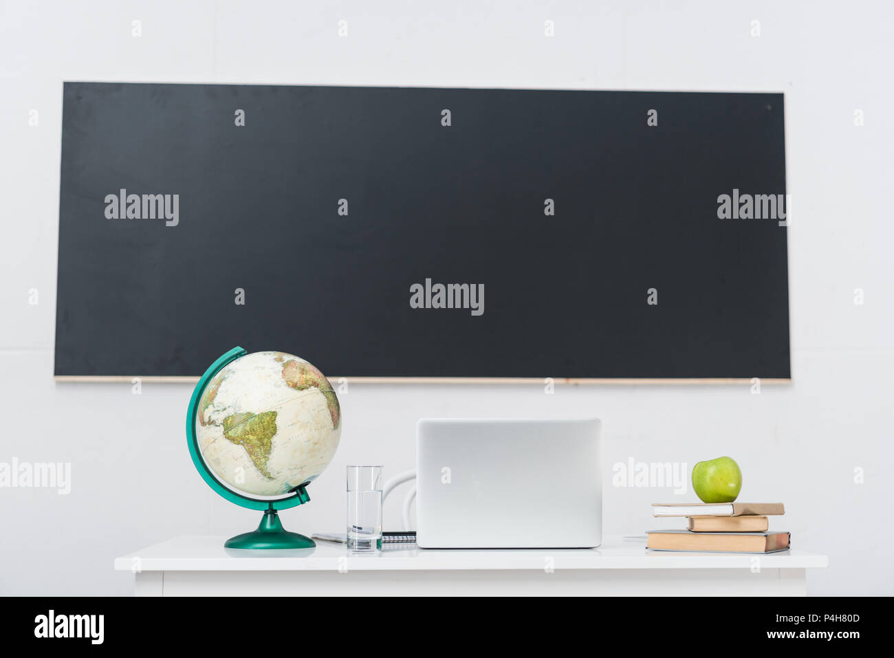 teachers desk with laptop in classroom in front of chalkboard Stock ...