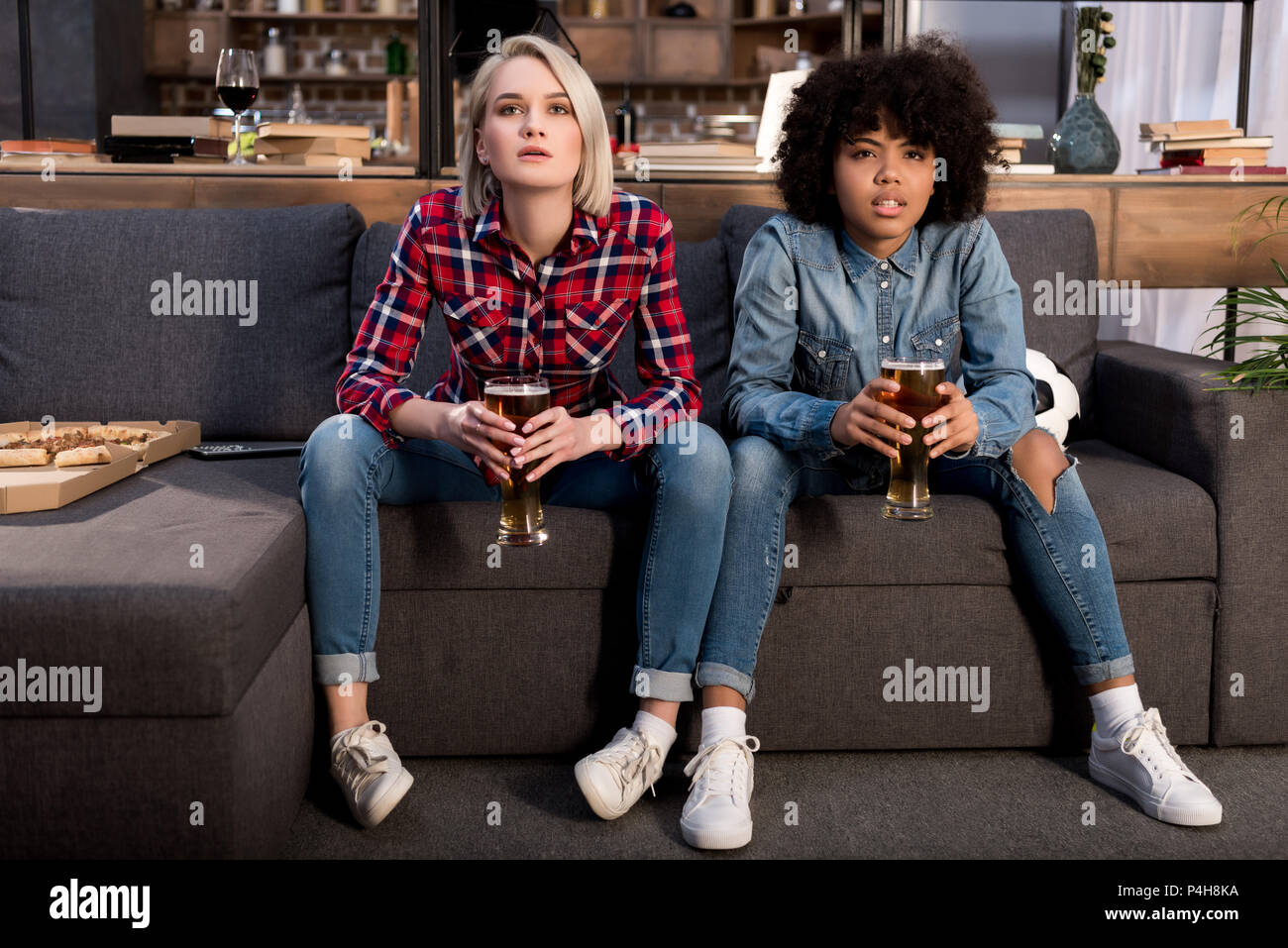 multicultural girls watching football on tv with beer Stock Photo - Alamy