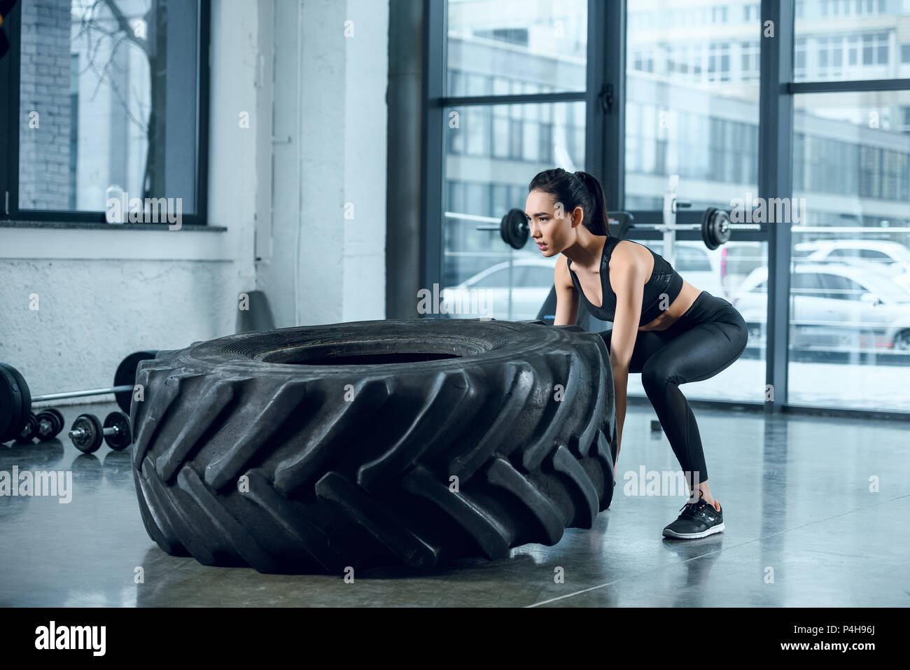 young athletic woman flipping workout wheel at gym Stock Photo - Alamy