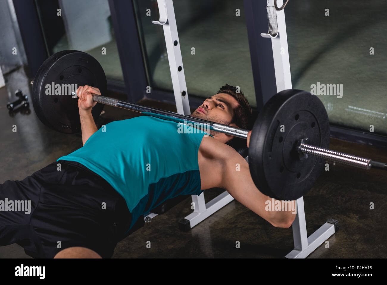 strong sportsman training with barbell in sports hall Stock Photo - Alamy