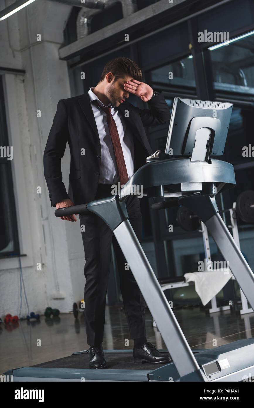 tired businessman training on treadmill in sports center Stock Photo ...