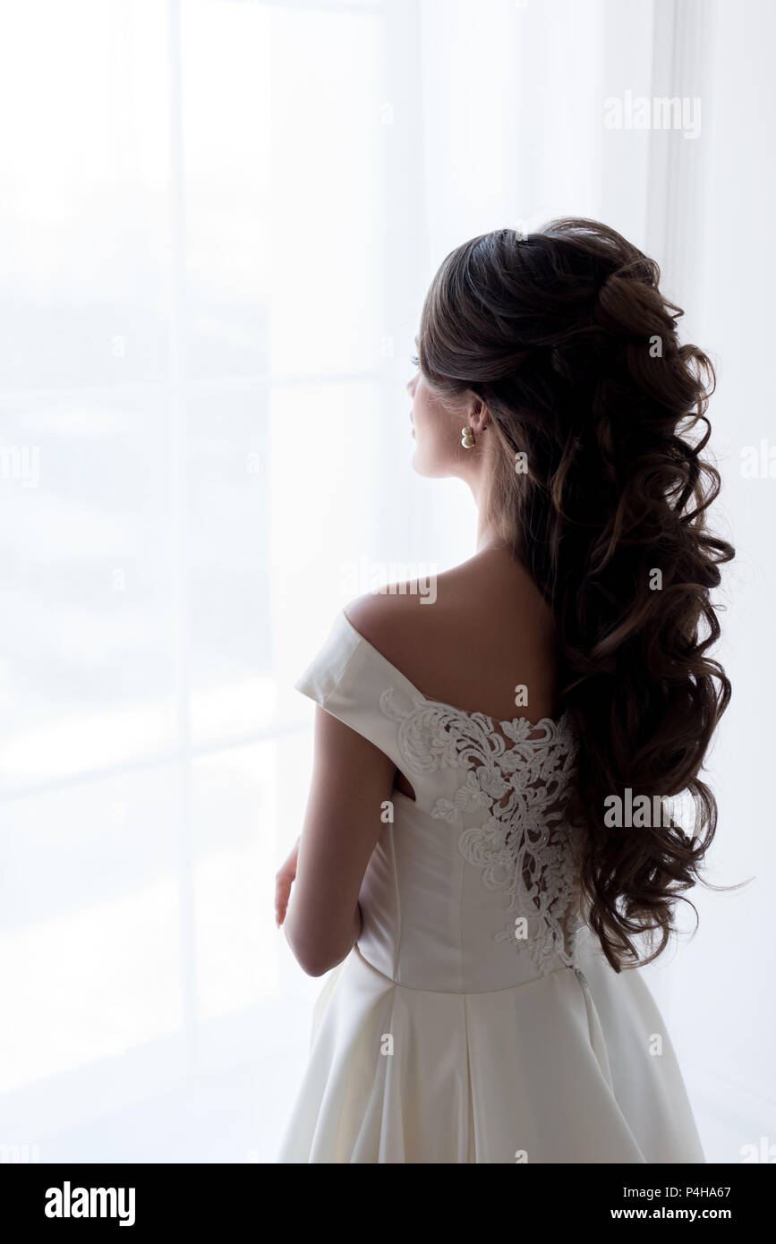 back view of bride in wedding dress looking at window Stock Photo - Alamy