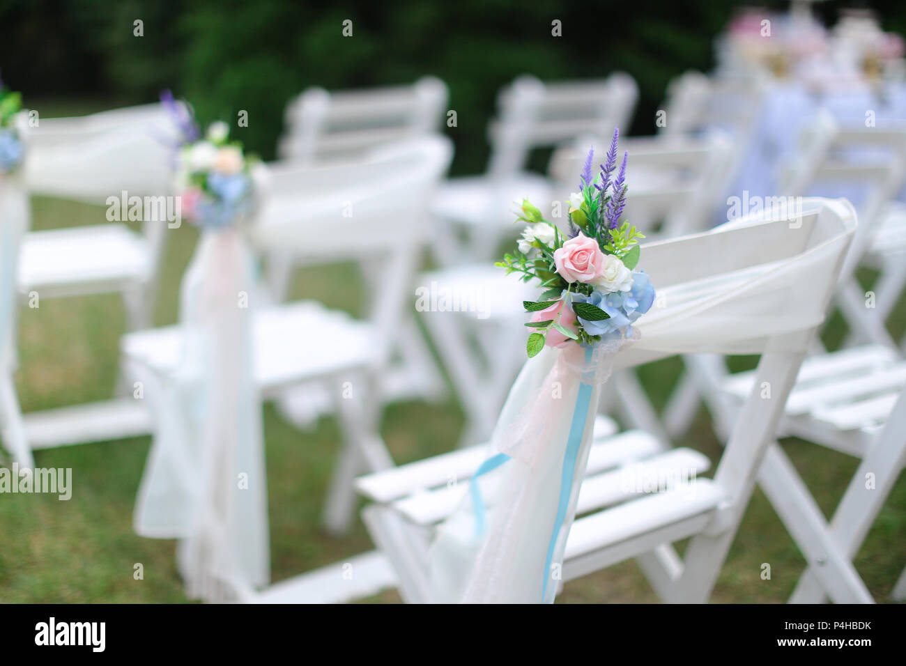 White chairs on green grass background Stock Photo - Alamy