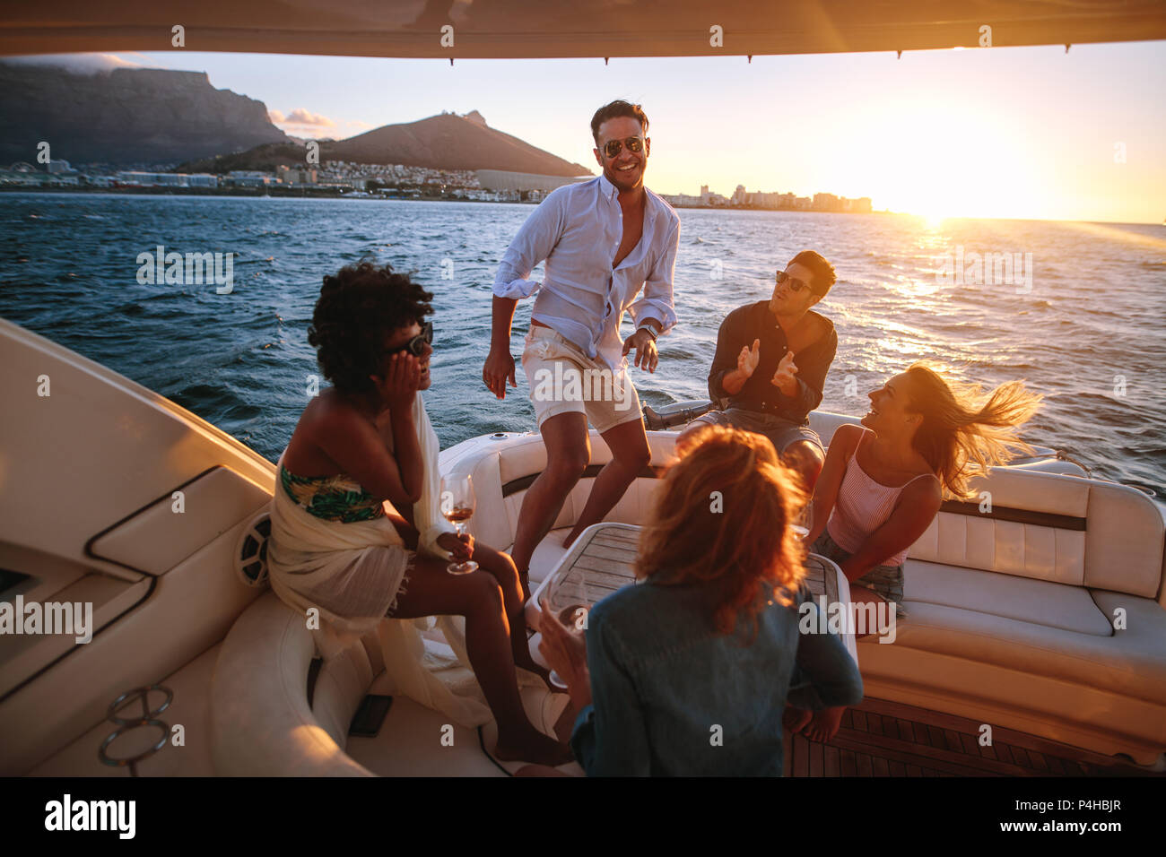 Group of young people dancing in boat party. Multiracial friends having ...