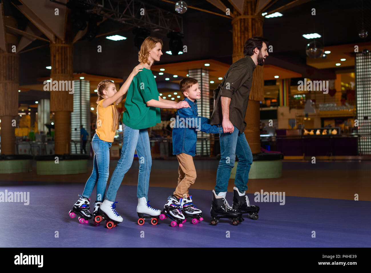parents and kids skating together on roller rink Stock Photo - Alamy