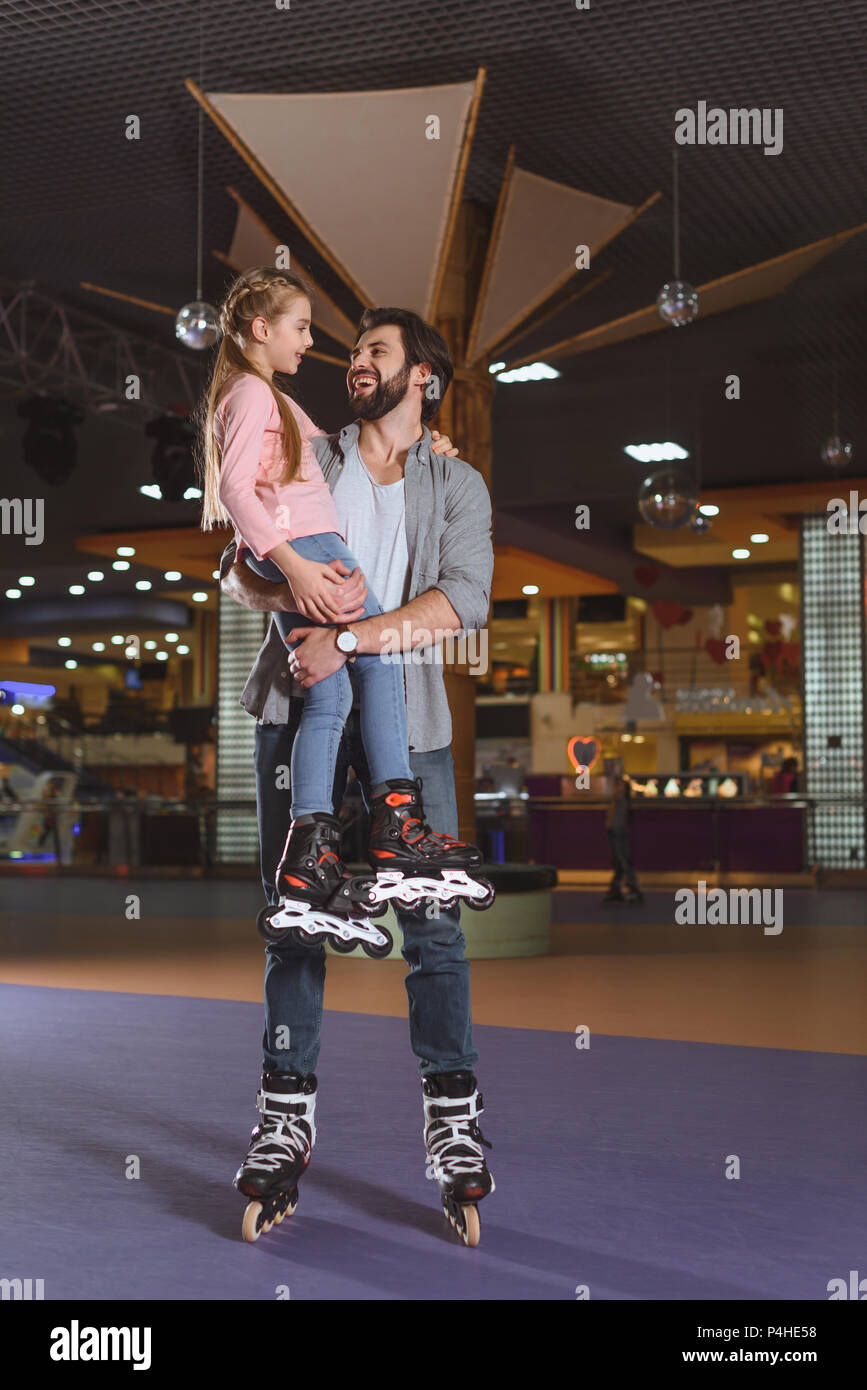 happy father holding daughter in roller skates on roller rink Stock ...