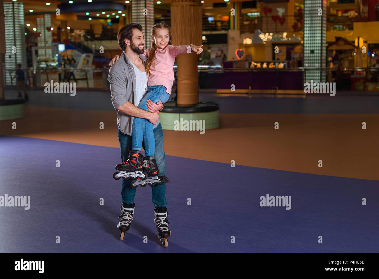 happy father holding daughter in roller skates on roller rink Stock ...