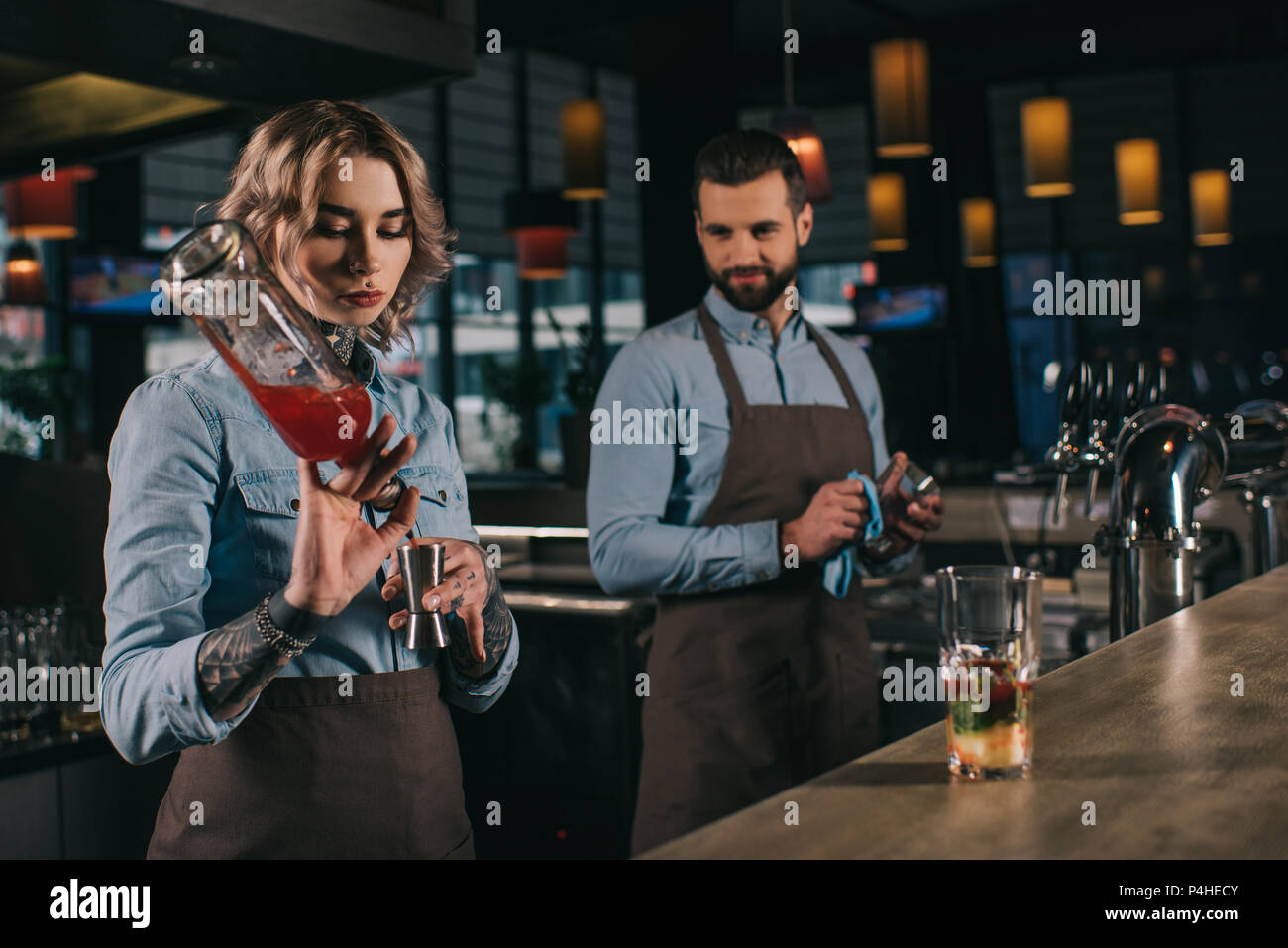 female and male bartenders working at bar Stock Photo - Alamy