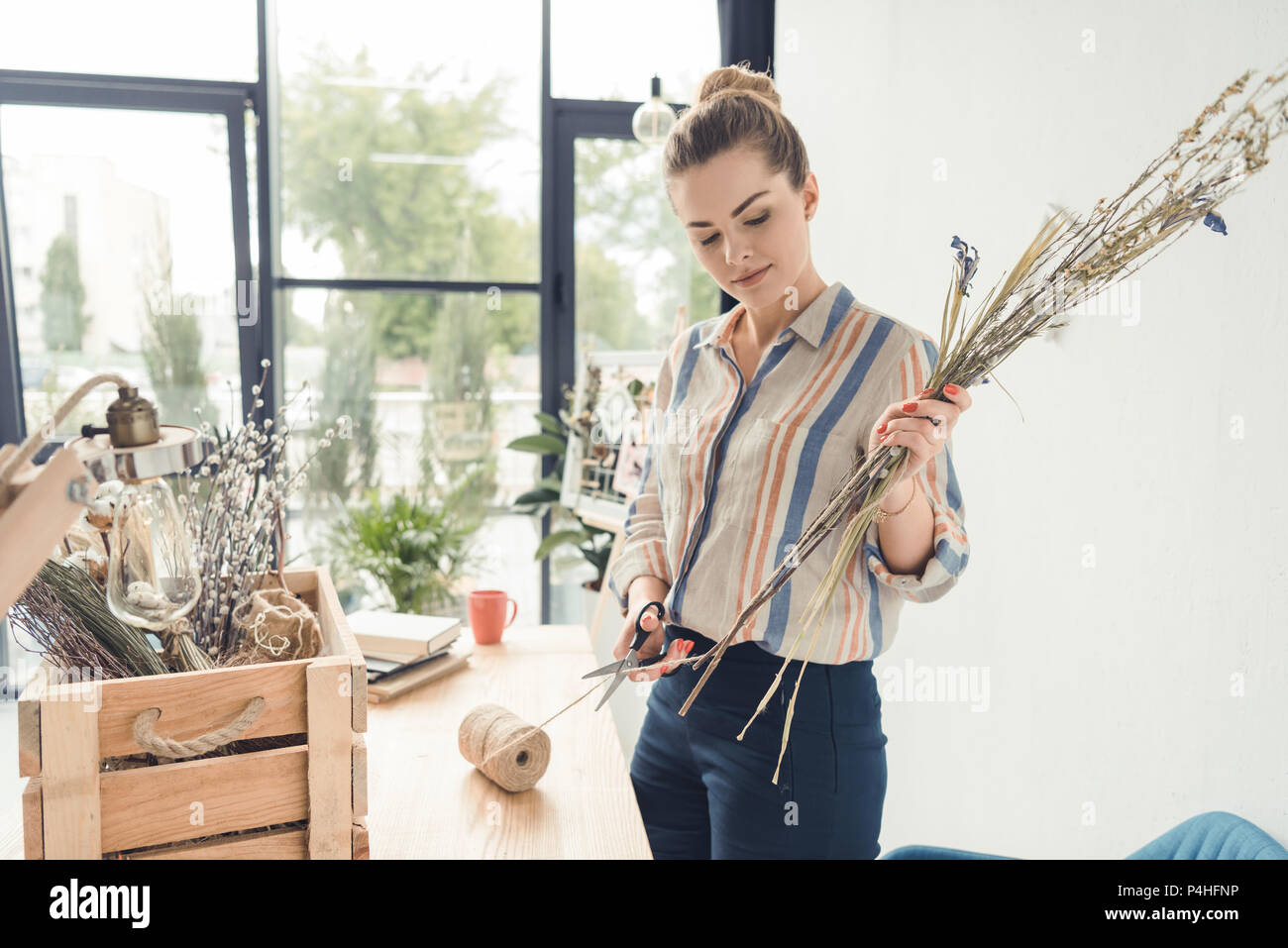 beautiful female decorator working with dry flowers at workplace Stock ...