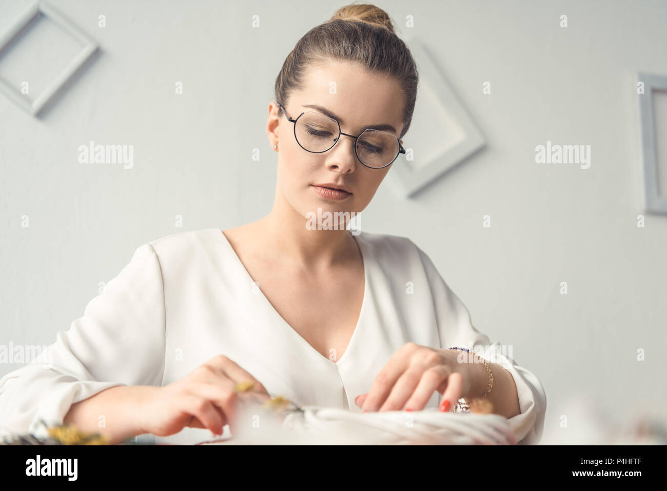 creative beautiful female decorator with white wreath at workplace ...