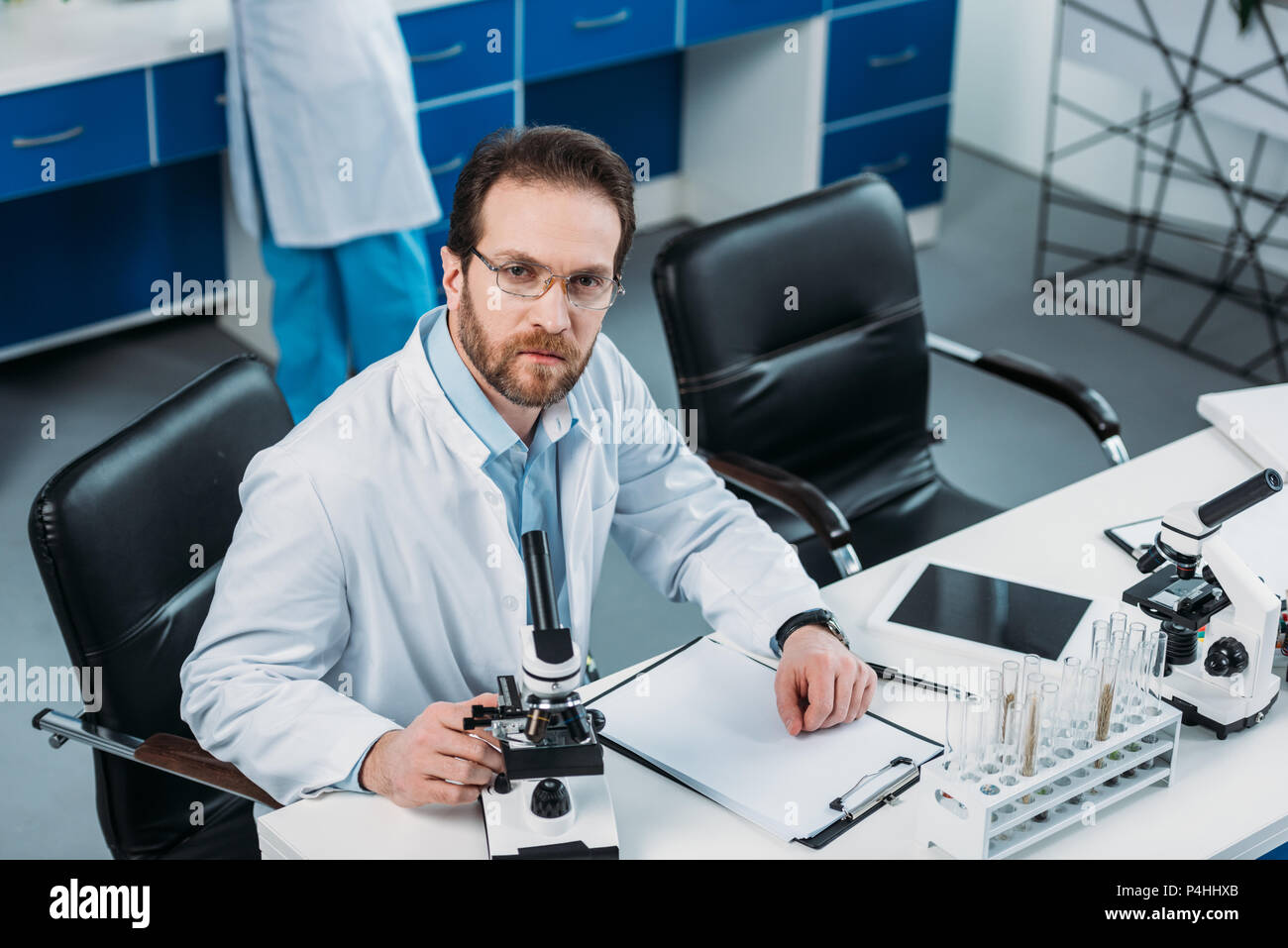 high angle view of scientist in white coat at workplace with ...