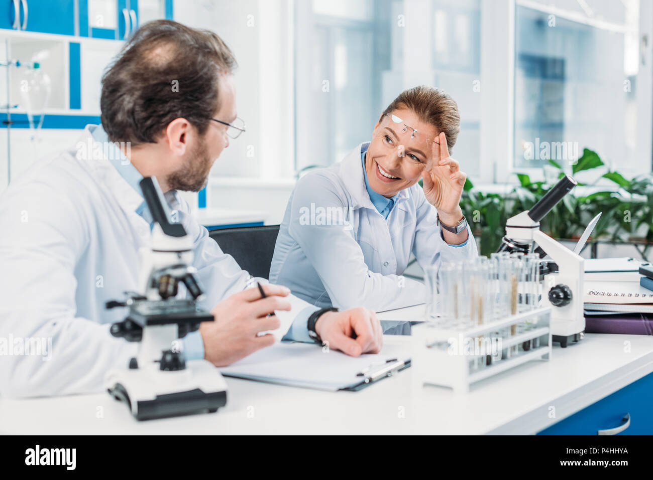 scientific researchers in white coats working together at workplace in ...