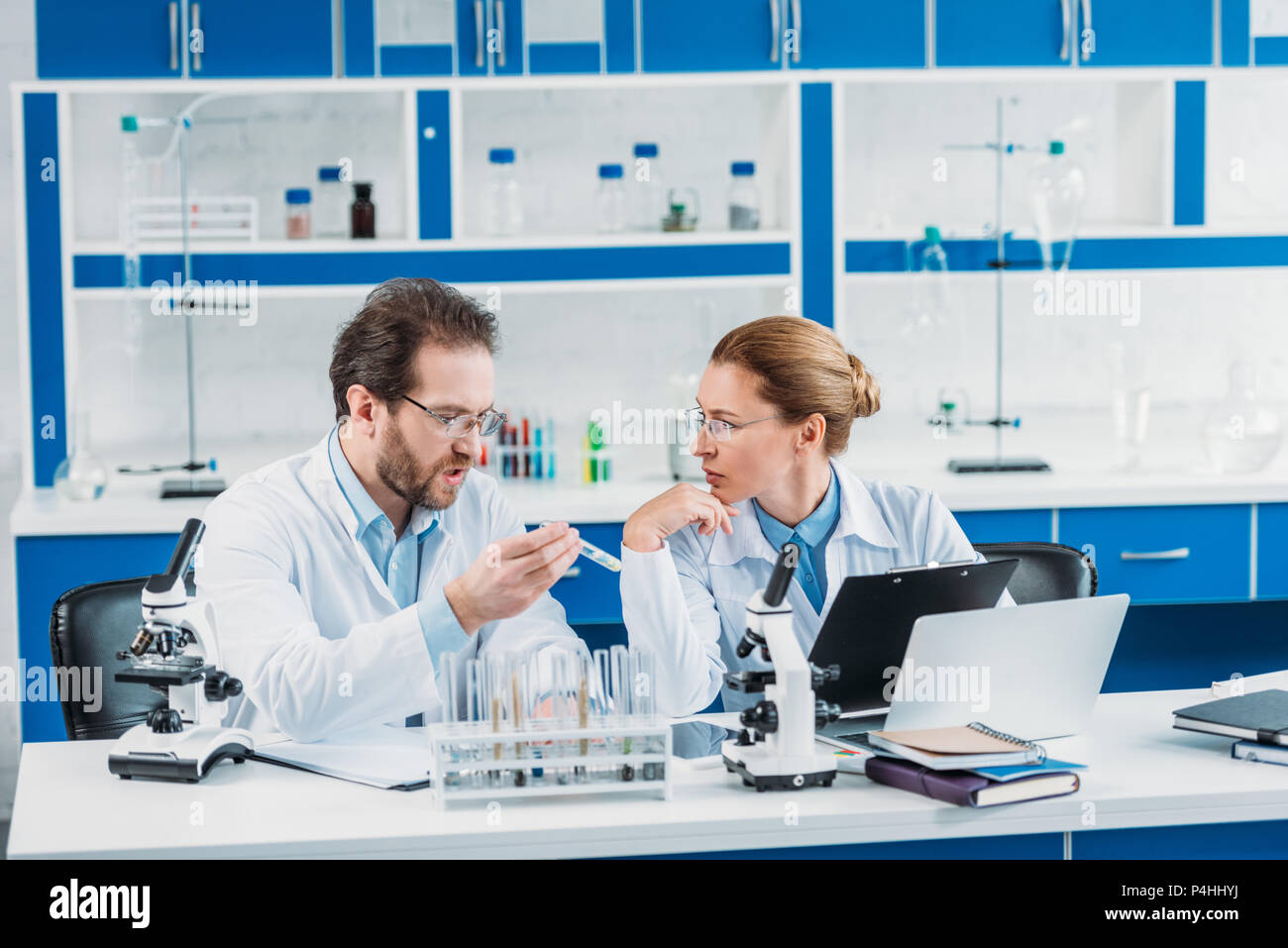 portrait of scientific researchers in white coats at workplace with ...