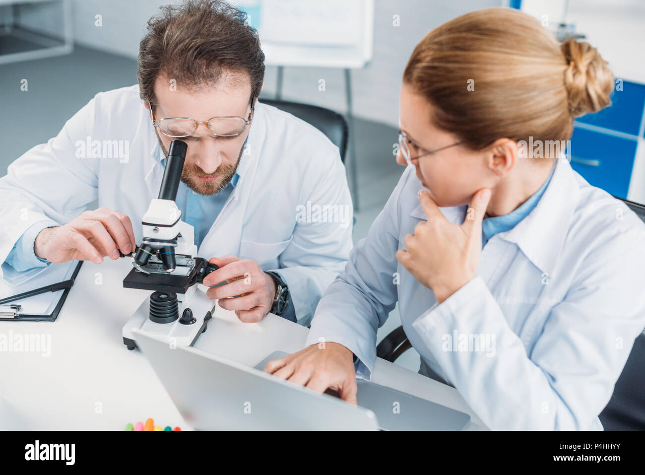 portrait of scientific researchers in white coats working together at ...
