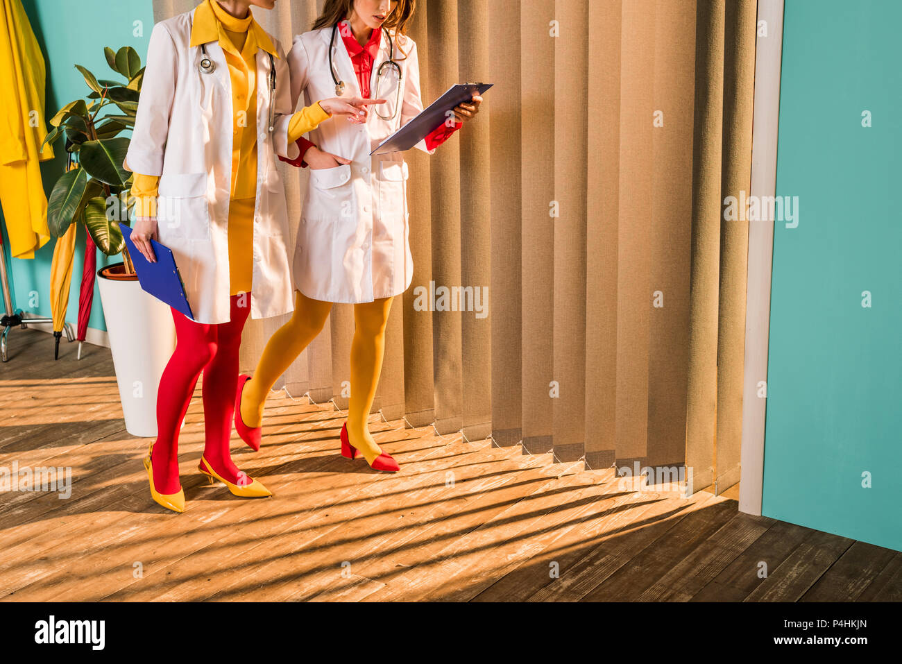 cropped image of retro styled doctors in colorful tights pointing on ...