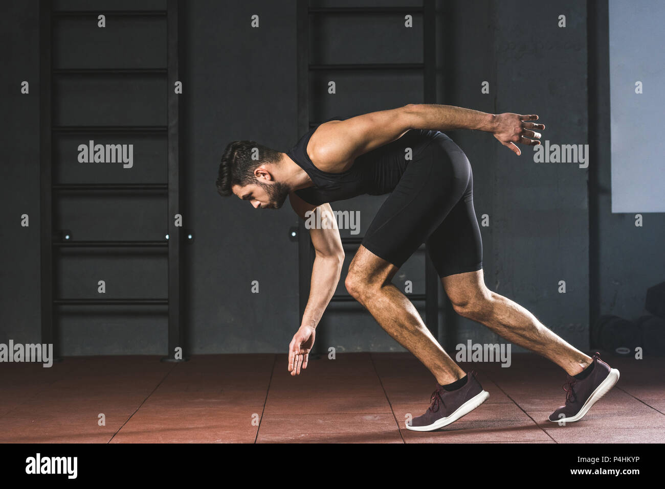 Side view of young sportsman running in gym Stock Photo - Alamy