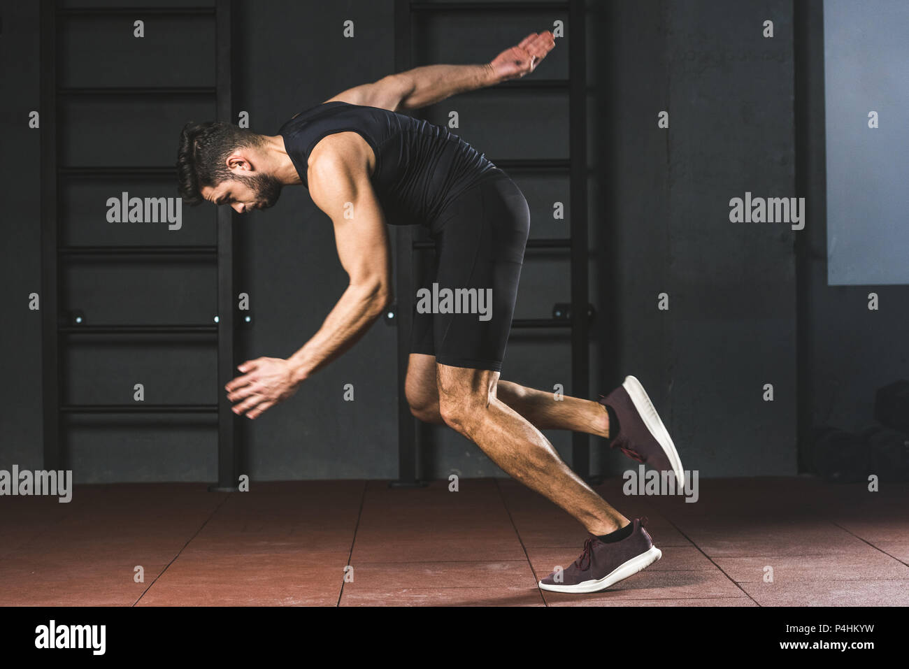 Side view of young sportsman running in sports center Stock Photo - Alamy