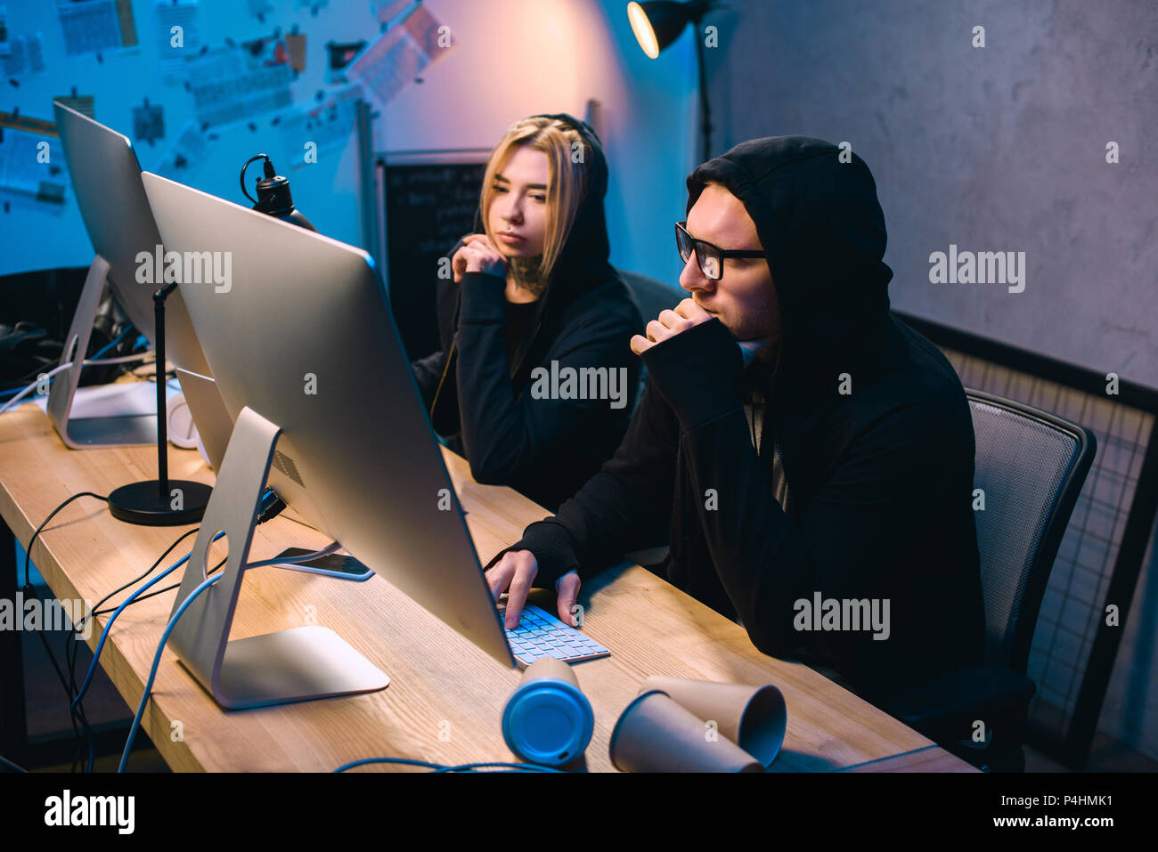 couple of young hackers working together in dark room Stock Photo - Alamy