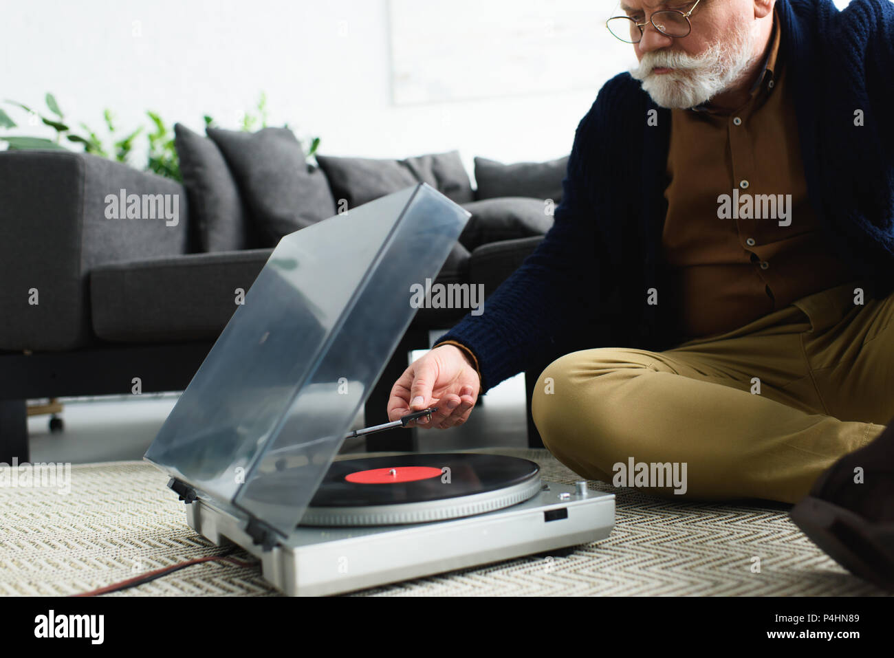cropped shot of senior man in eyeglasses listening music with vinyl ...