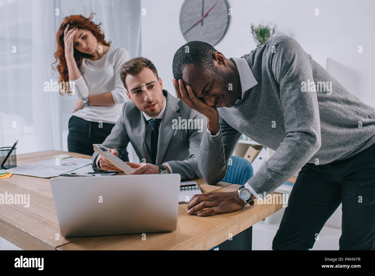 Financial adviser showing calculation to upset business partners Stock ...