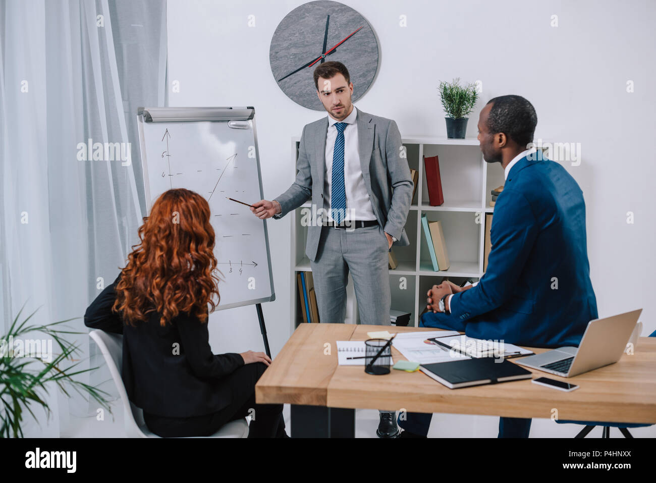 Financial adviser showing presentation to clients Stock Photo - Alamy