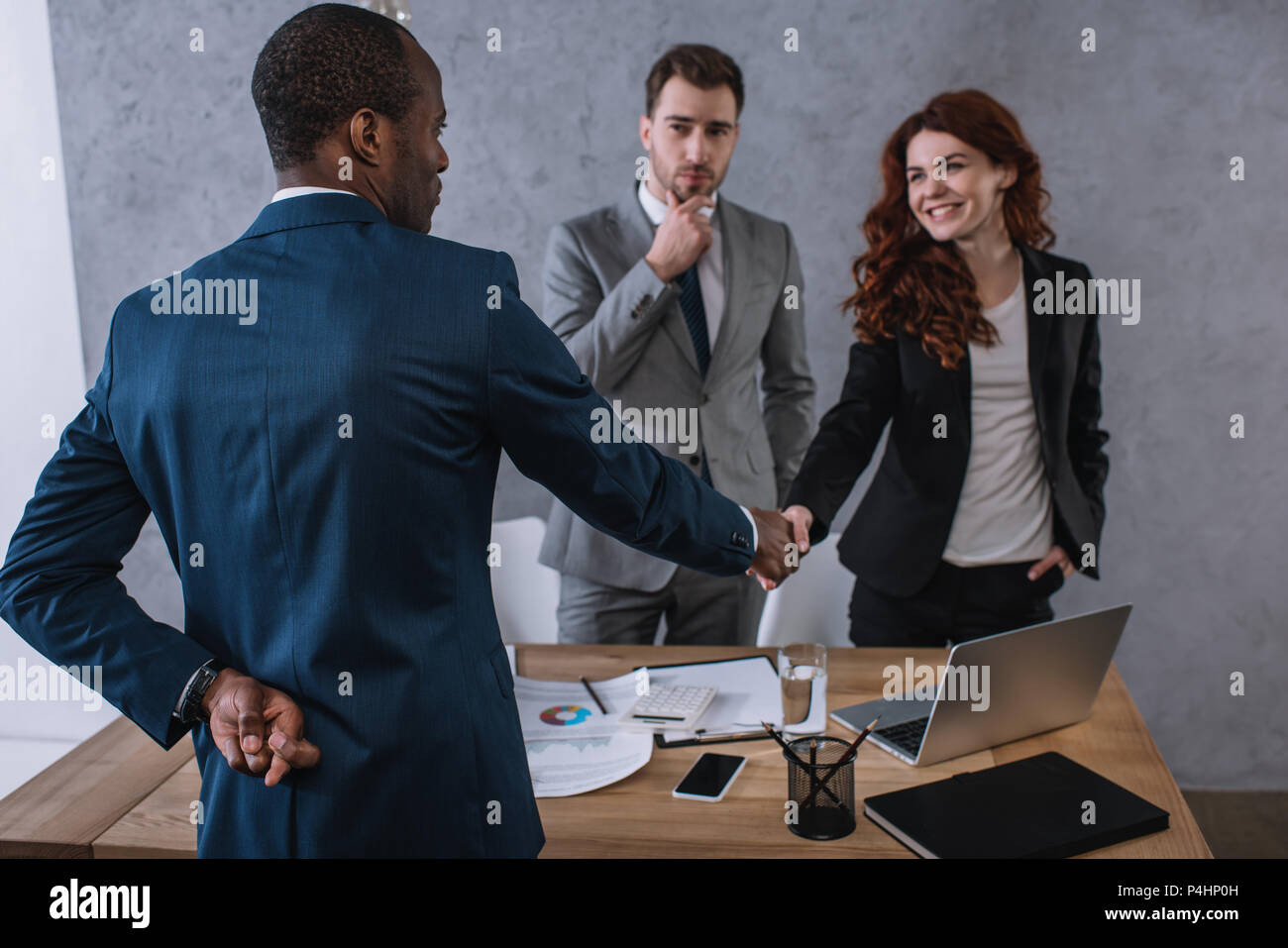 Businessman with fingers crossed shaking hand to partner Stock Photo ...