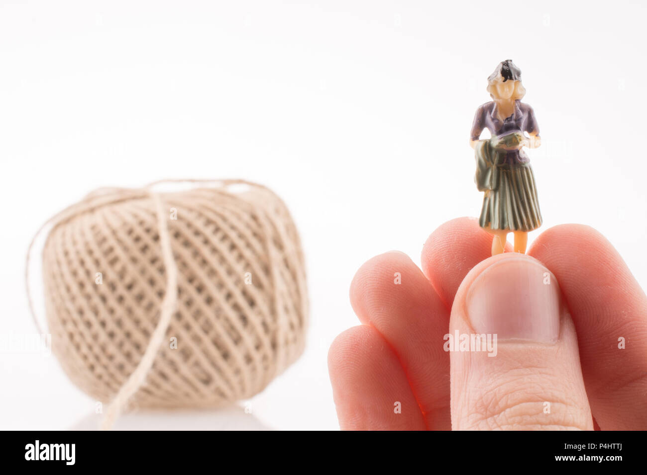 Woman figure beside a linen spool of thread on a white background Stock ...