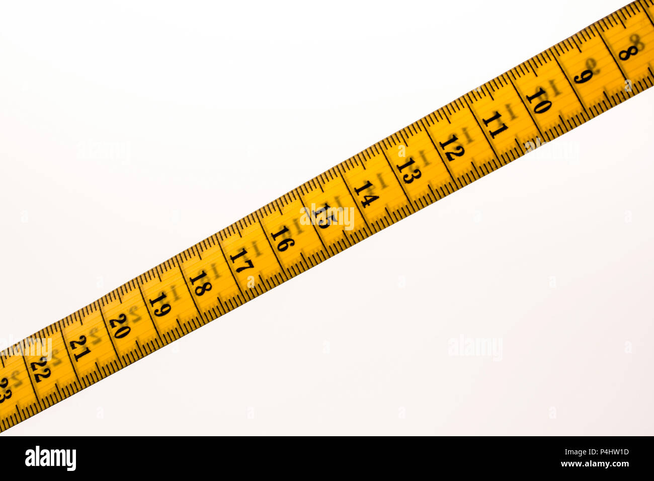 Yellow color measuring tape on a white background Stock Photo - Alamy