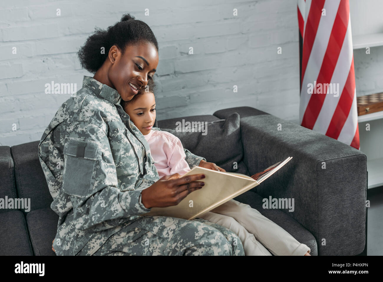 Mother soldier and african american child reading book Stock Photo - Alamy
