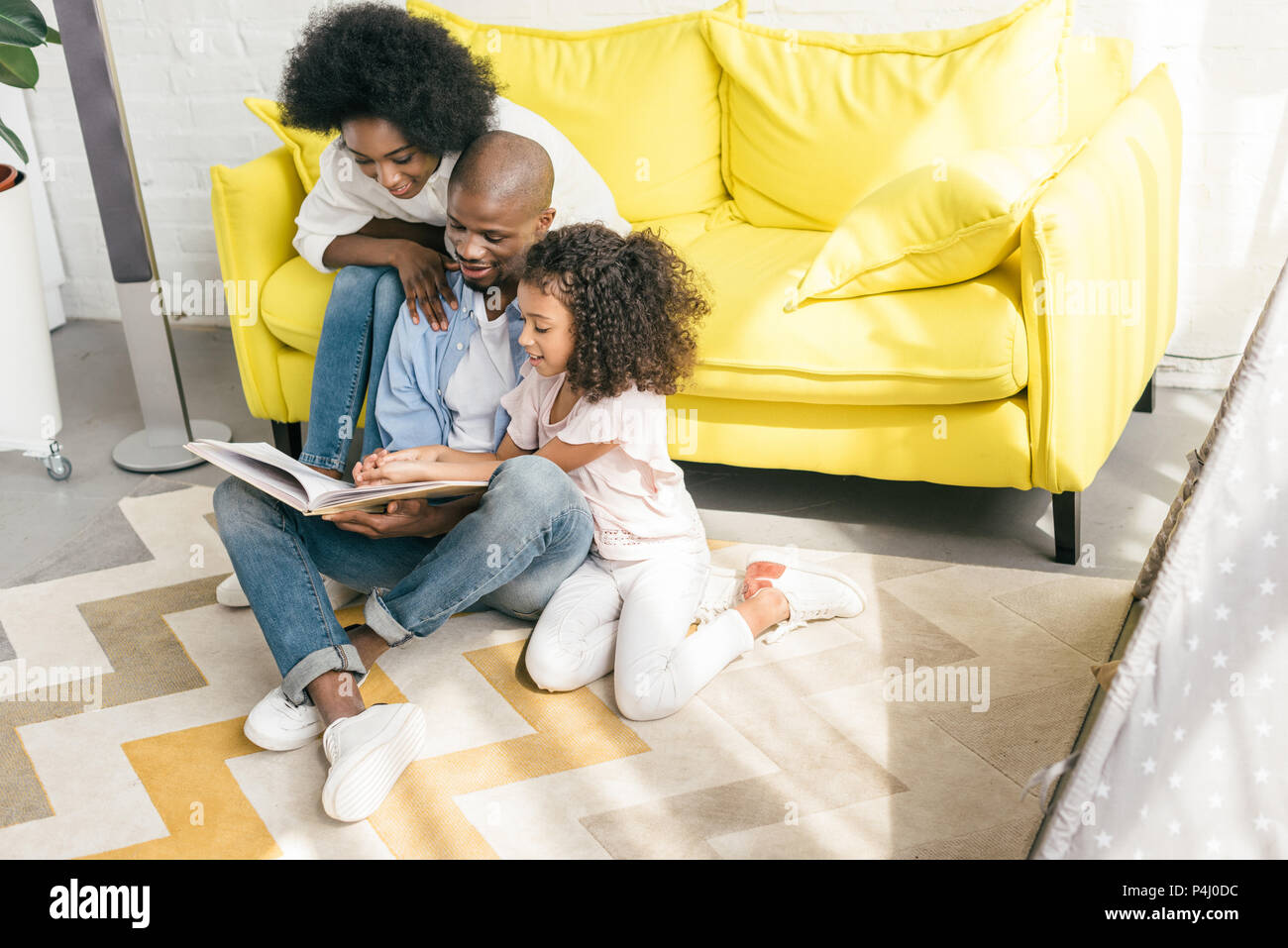 african american family reading book together at home Stock Photo - Alamy