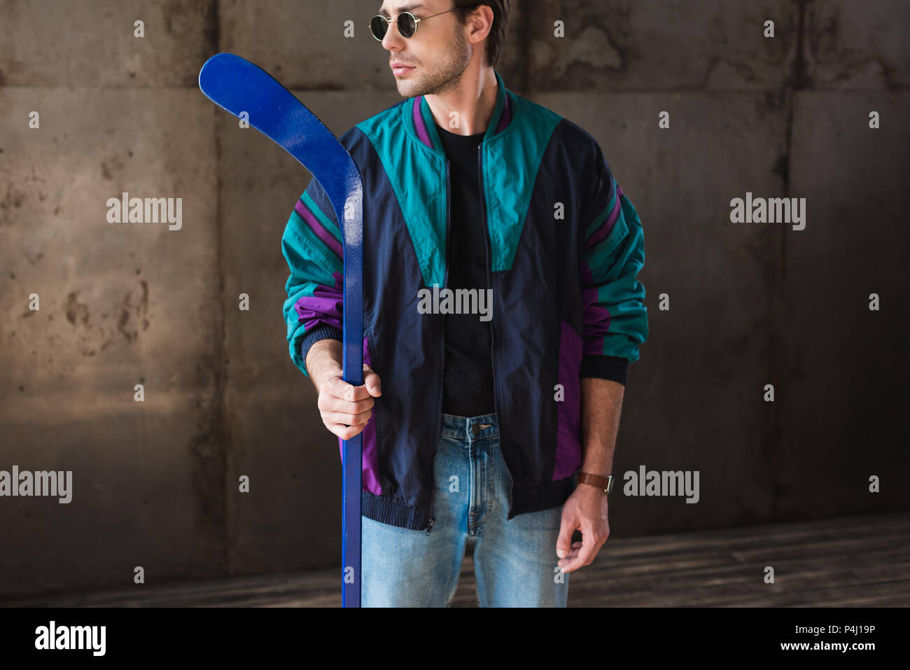 stylish young man in vintage windcheater and sunglasses with hockey ...