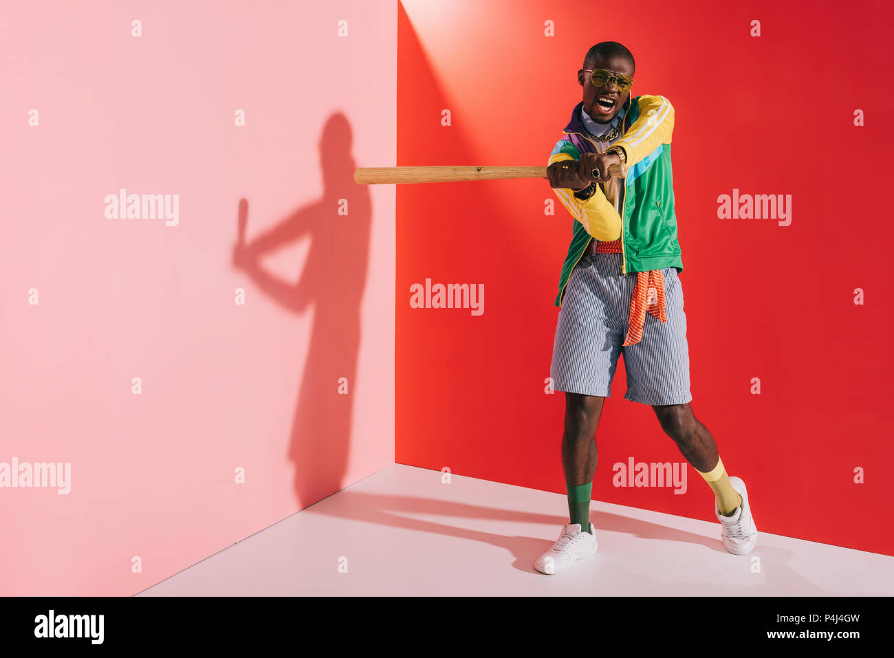 aggressive young african american man holding baseball bat and ...