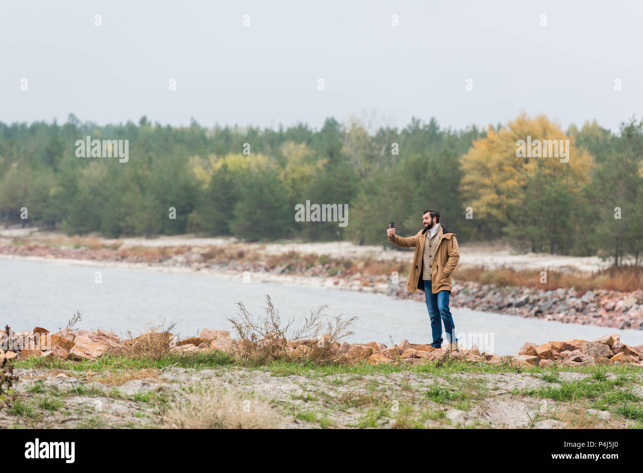 lonely happy man taking photo of landscape with smartphone Stock Photo ...
