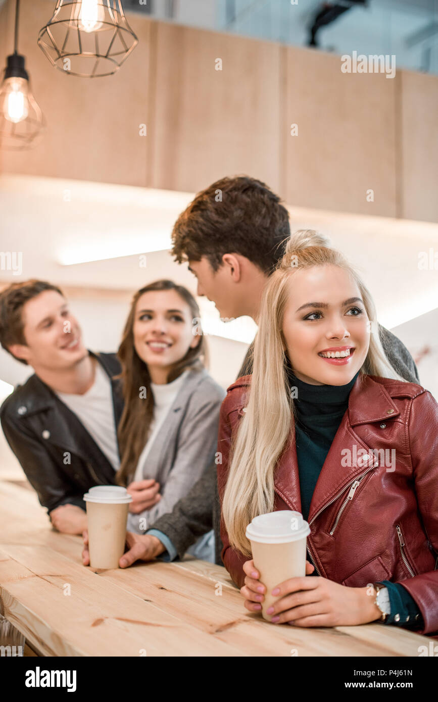 Four friends standing with a coffee at bar counter Stock Photo - Alamy