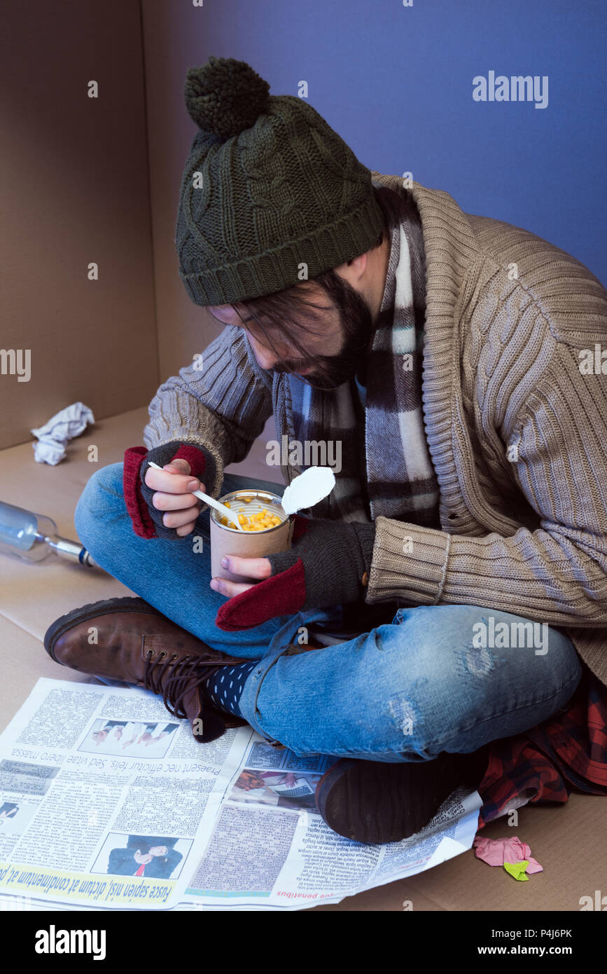muddy homeless man eating canned food in cardboard box Stock Photo - Alamy
