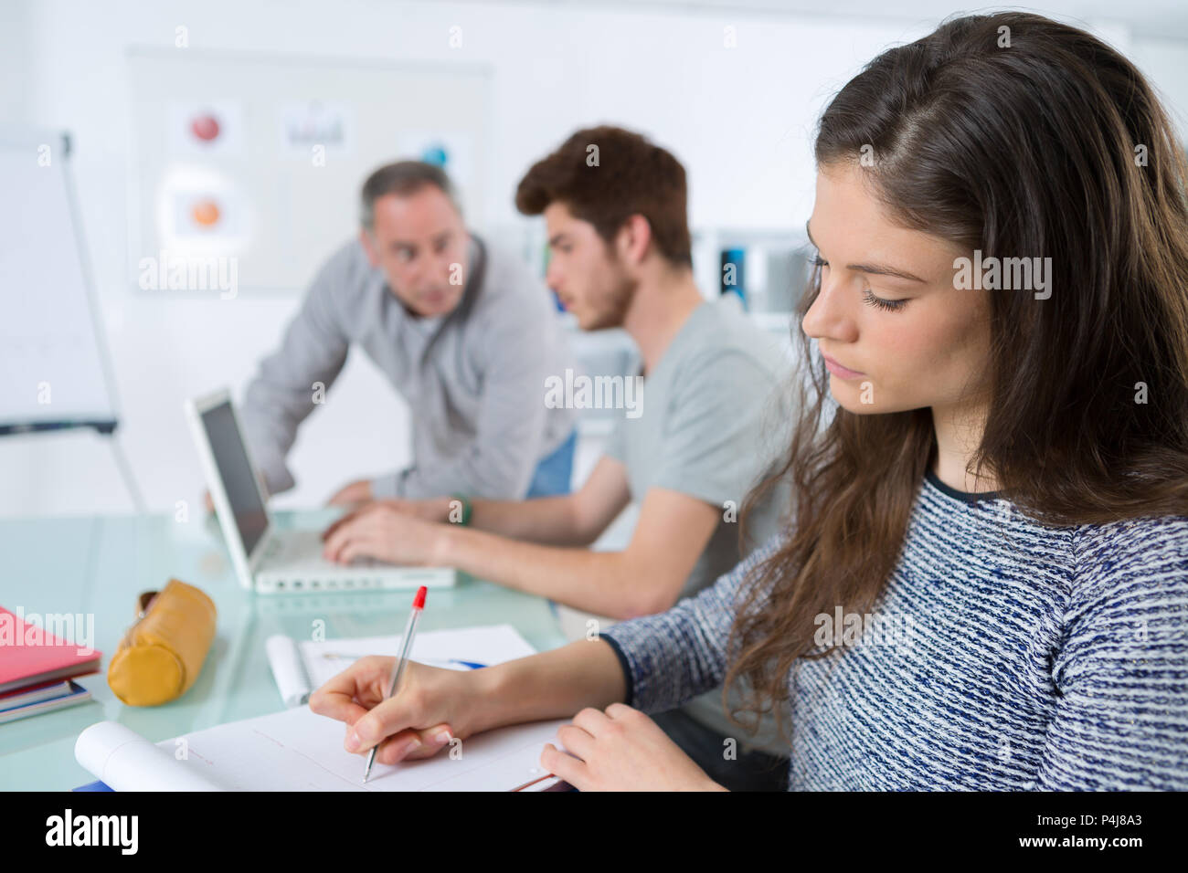serious young female student taking notes in class Stock Photo - Alamy