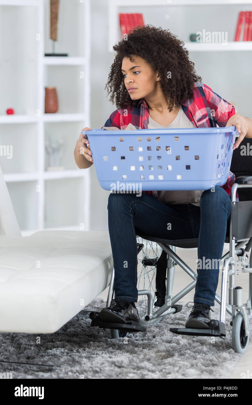 Disabled lady with laundry basket on her lap Stock Photo - Alamy