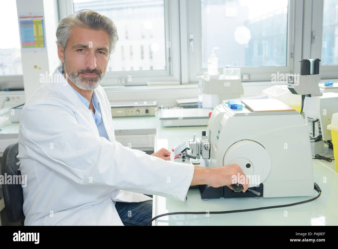 Portrait of laboratory technician operating equipment Stock Photo - Alamy