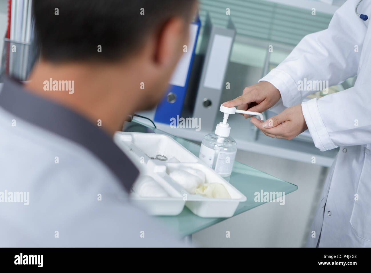 Medical worker dispensing antibacterial gel onto hand Stock Photo - Alamy