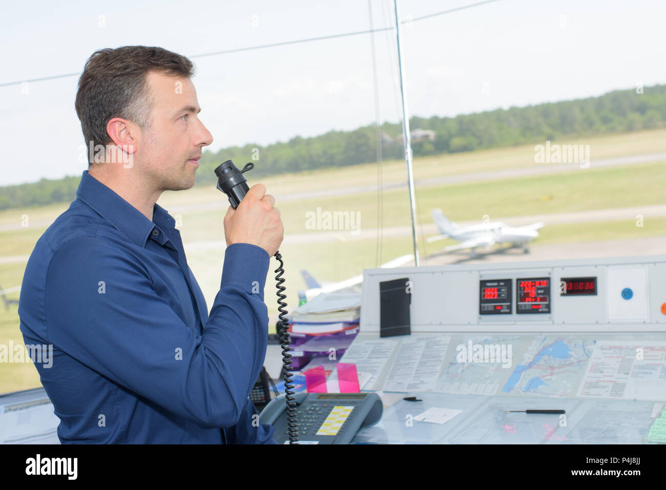 Man in control tower speaking into microphone Stock Photo - Alamy