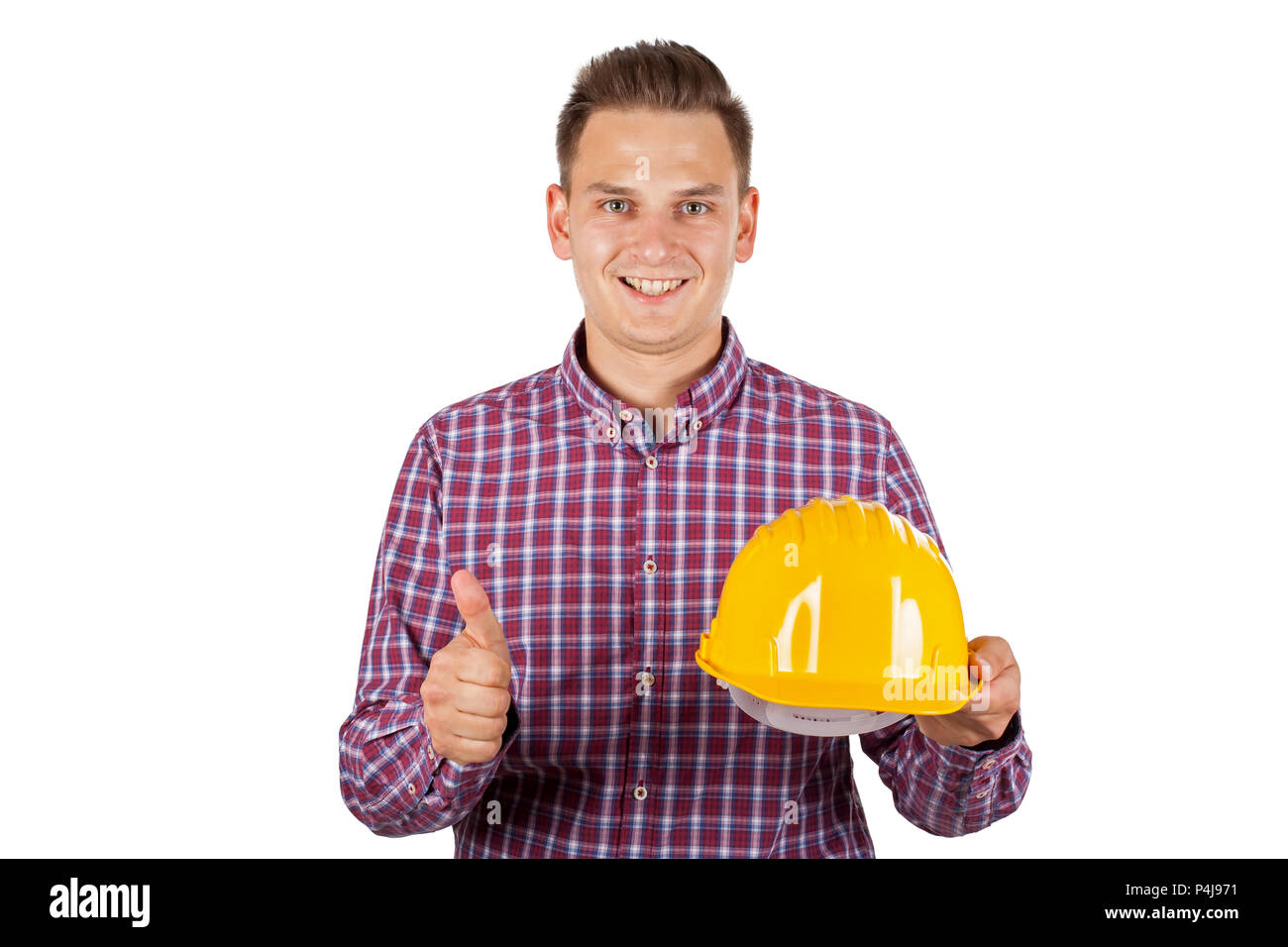 Smiling young engineer with yellow helmet showing thumbs up on isolated ...