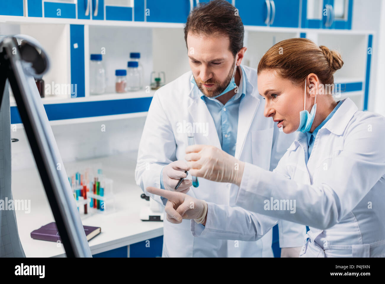 scientist in white coats near board for notes having discussion during ...