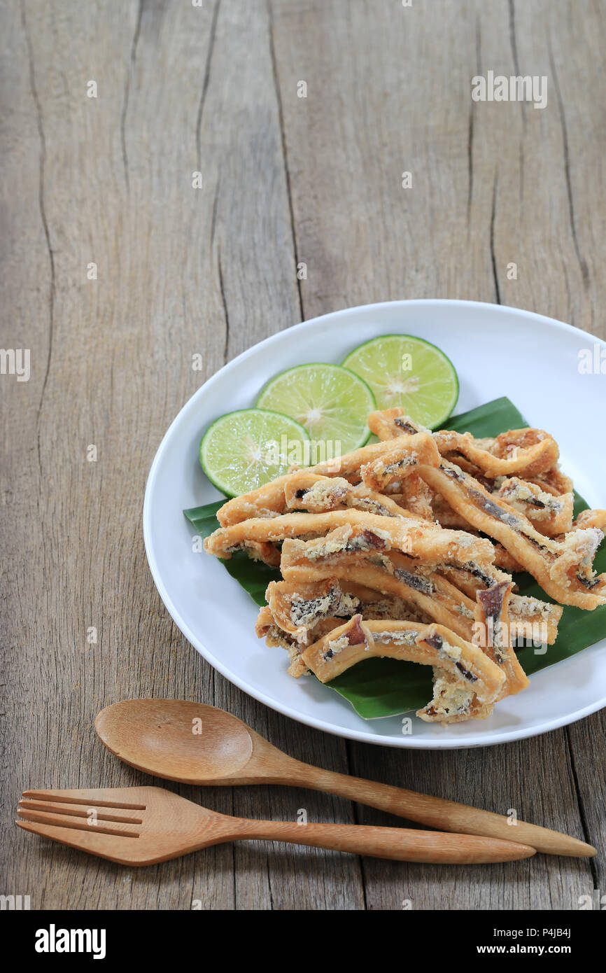 fried squid of Thai seafoods in the white dish on wood floor and have ...