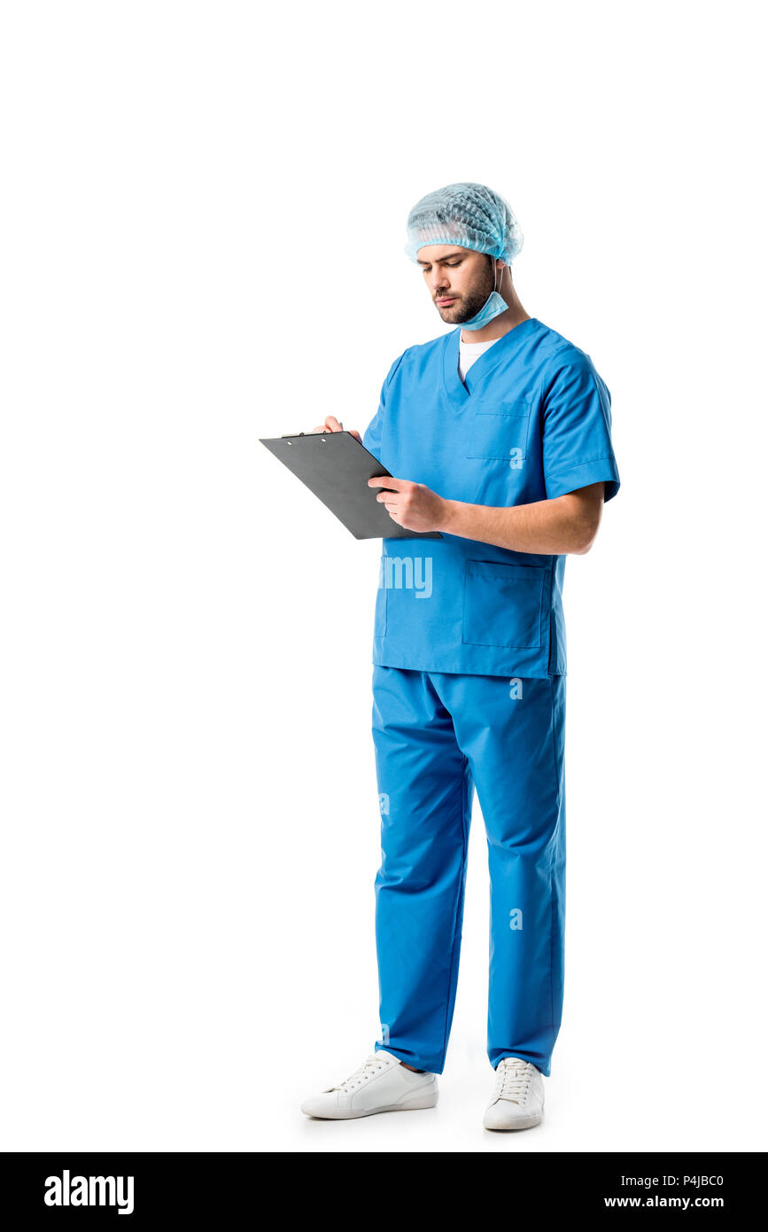 Thoughtful medical worker wearing blue uniform and writing in clipboard ...